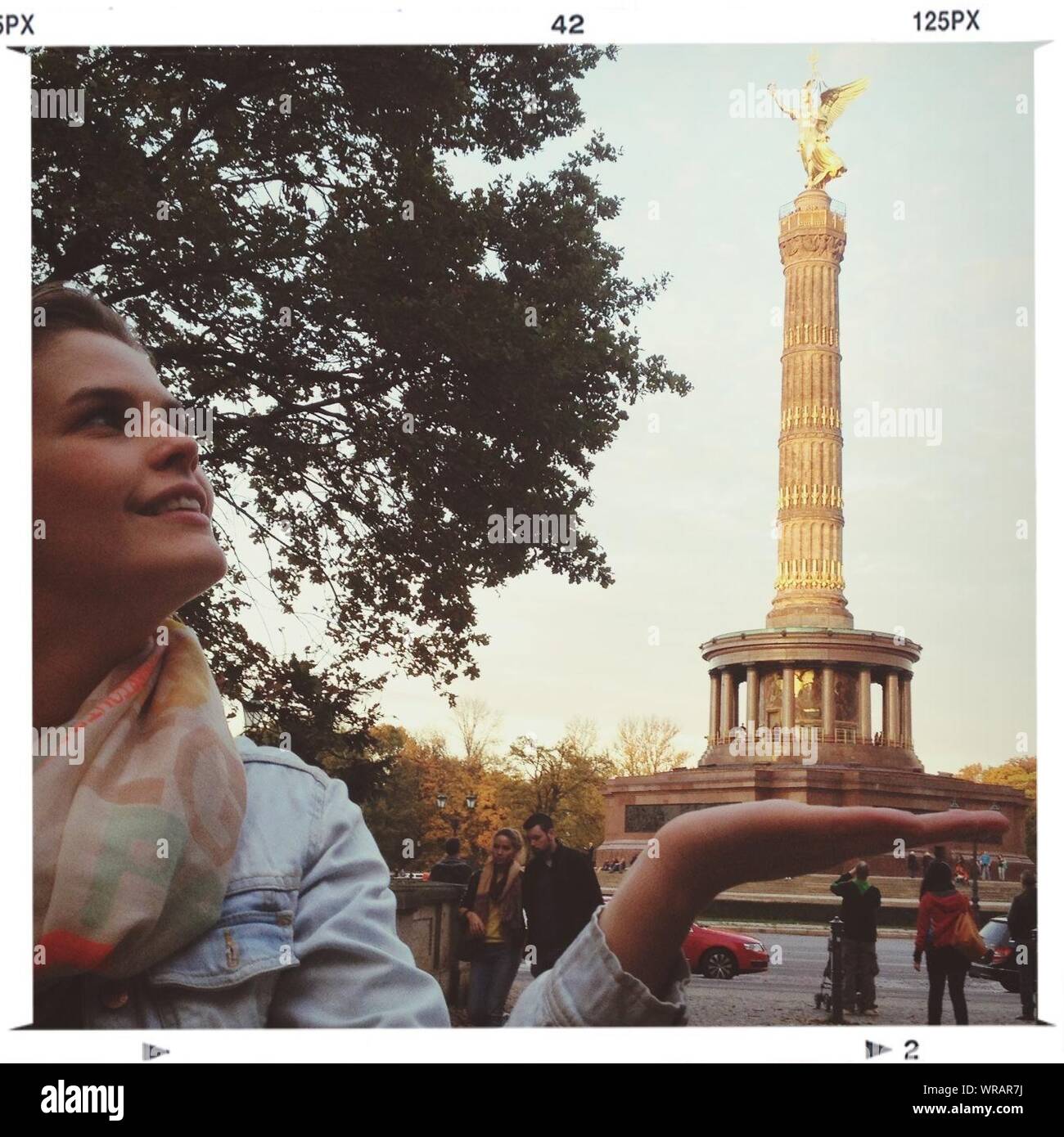 Optical Illusion Of Young Woman Holding Victory Column Stock Photo - Alamy