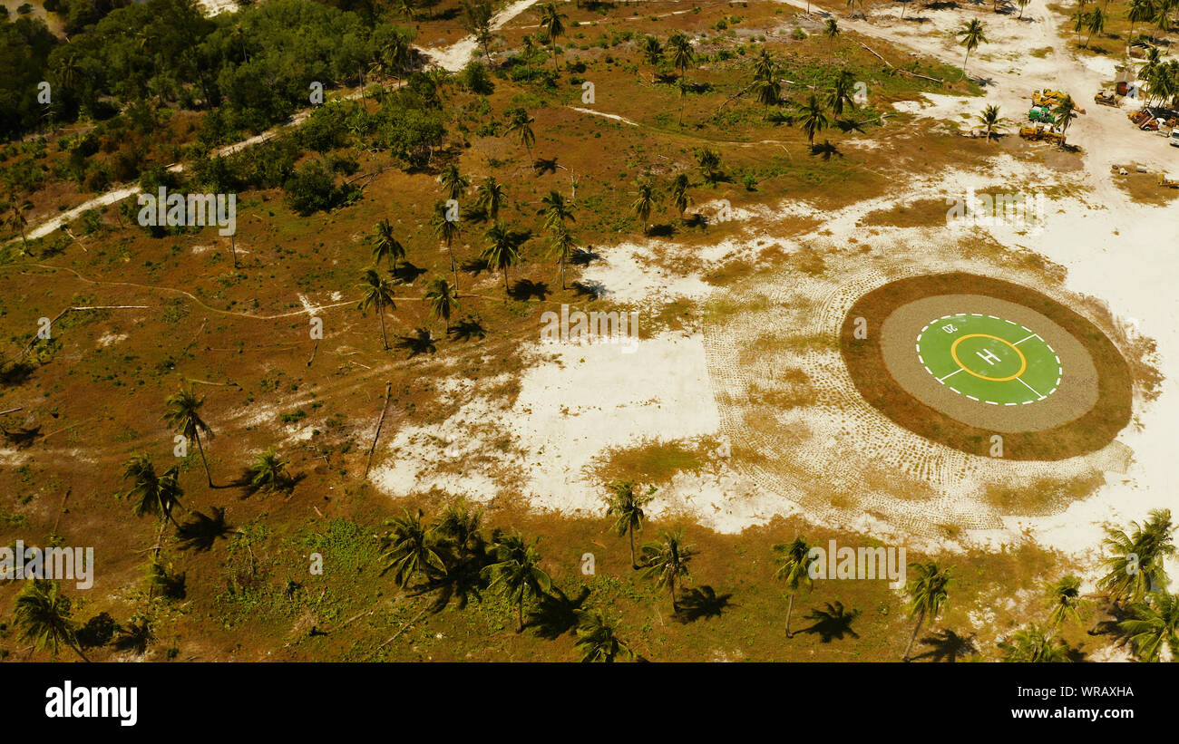 Helipad among the palm trees on a tropical island top view. Helicopter ...