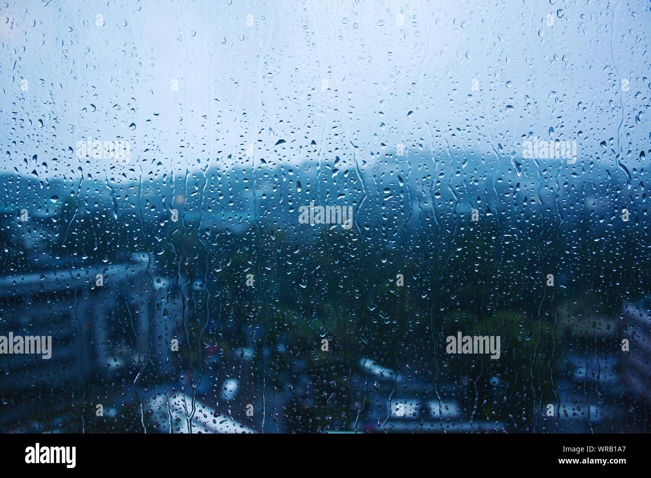 Buildings Seen Through Glass Window On Rainy Day Stock Photo - Alamy
