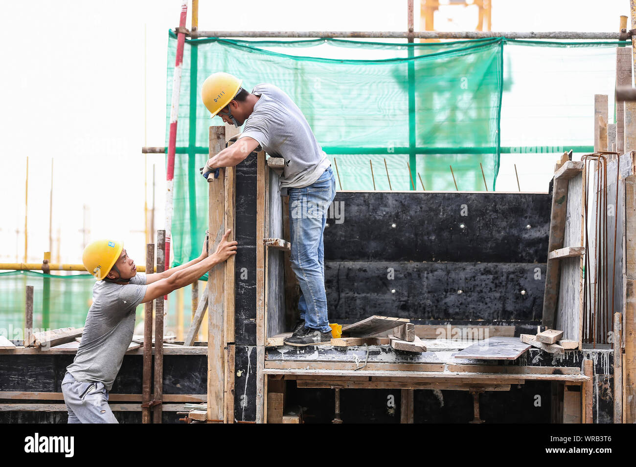 Chinese migrant workers construct a high-rise residential apartment ...