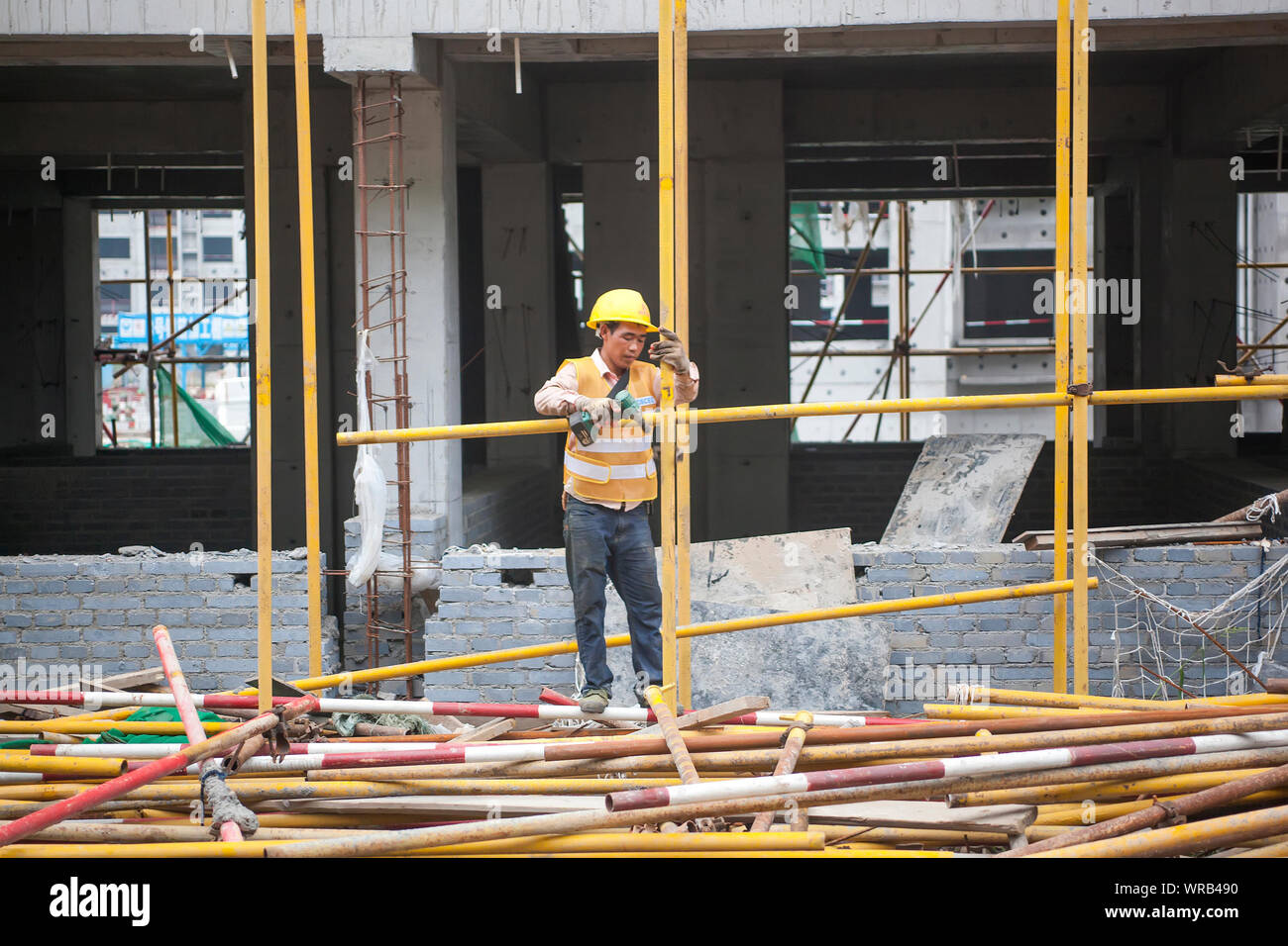 A Chinese migrant worker constructs a high-rise residential apartment ...