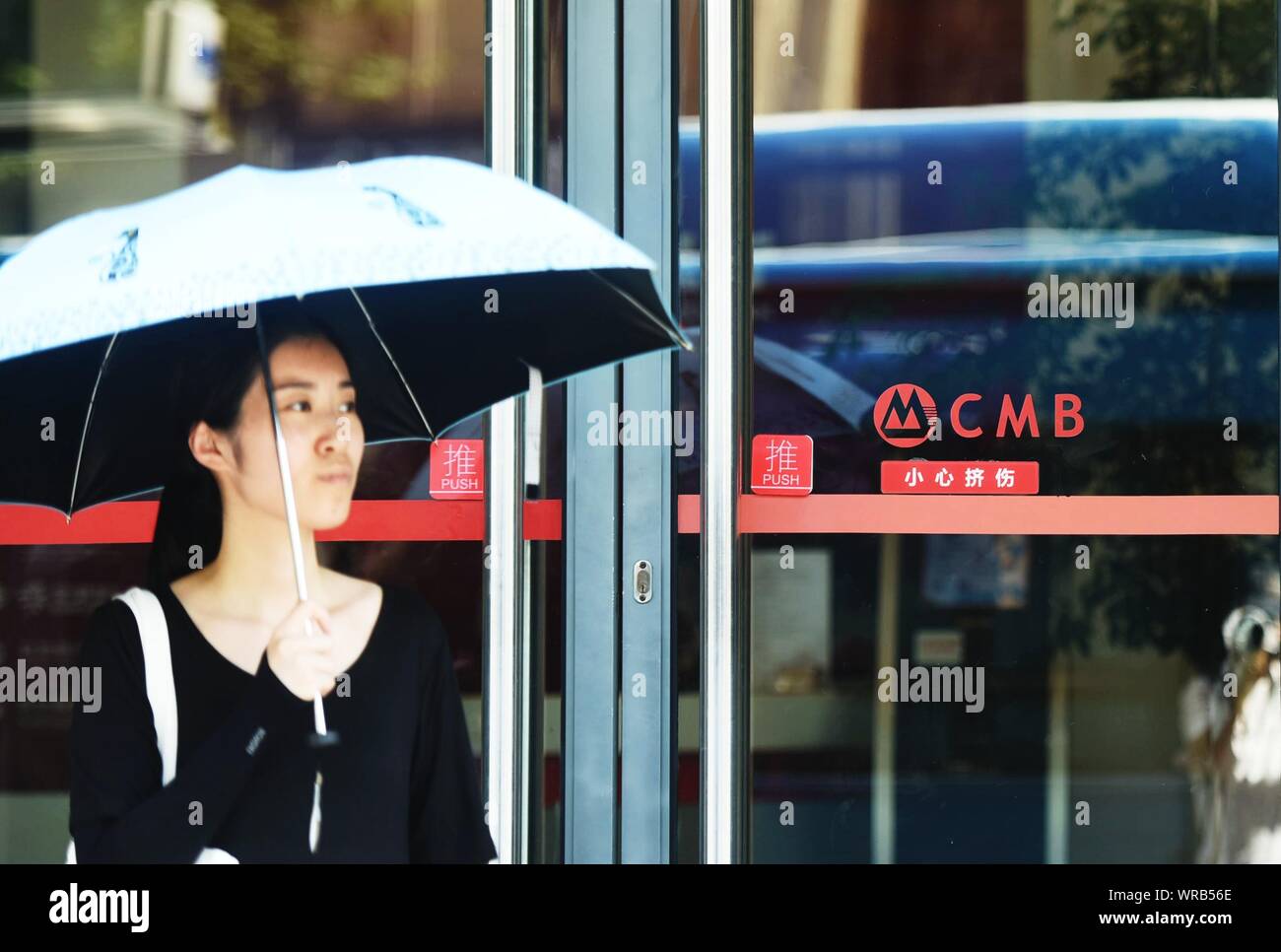 A Chinese pedestrian walks past a branch of China Merchants Bank (CMB ...