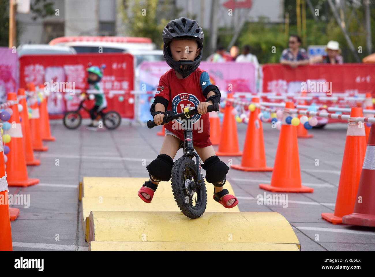 A young Chinese boy wearing a safety helmet cycles during a cycling ...