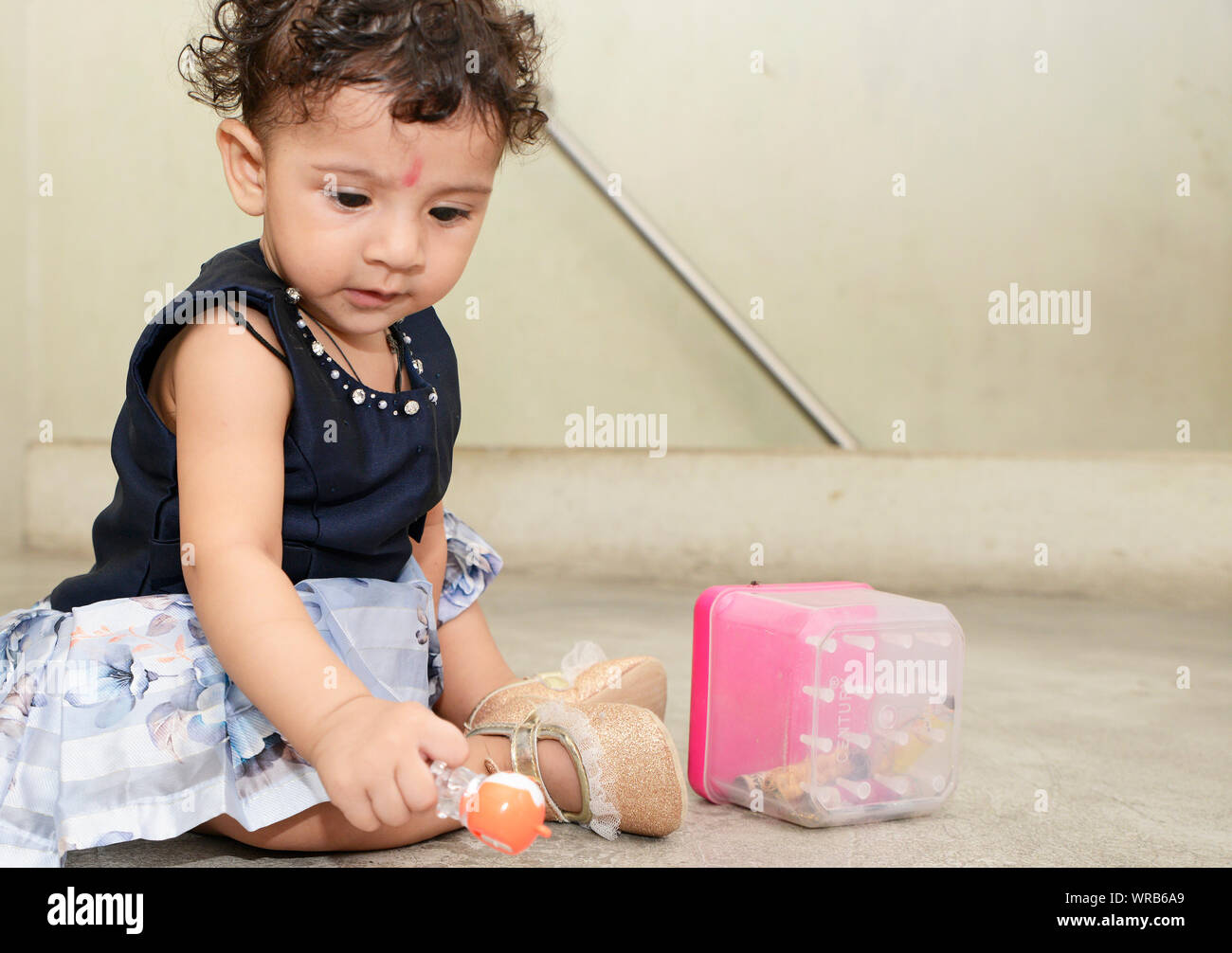 Baby girl playing On Floor Stock Photo - Alamy