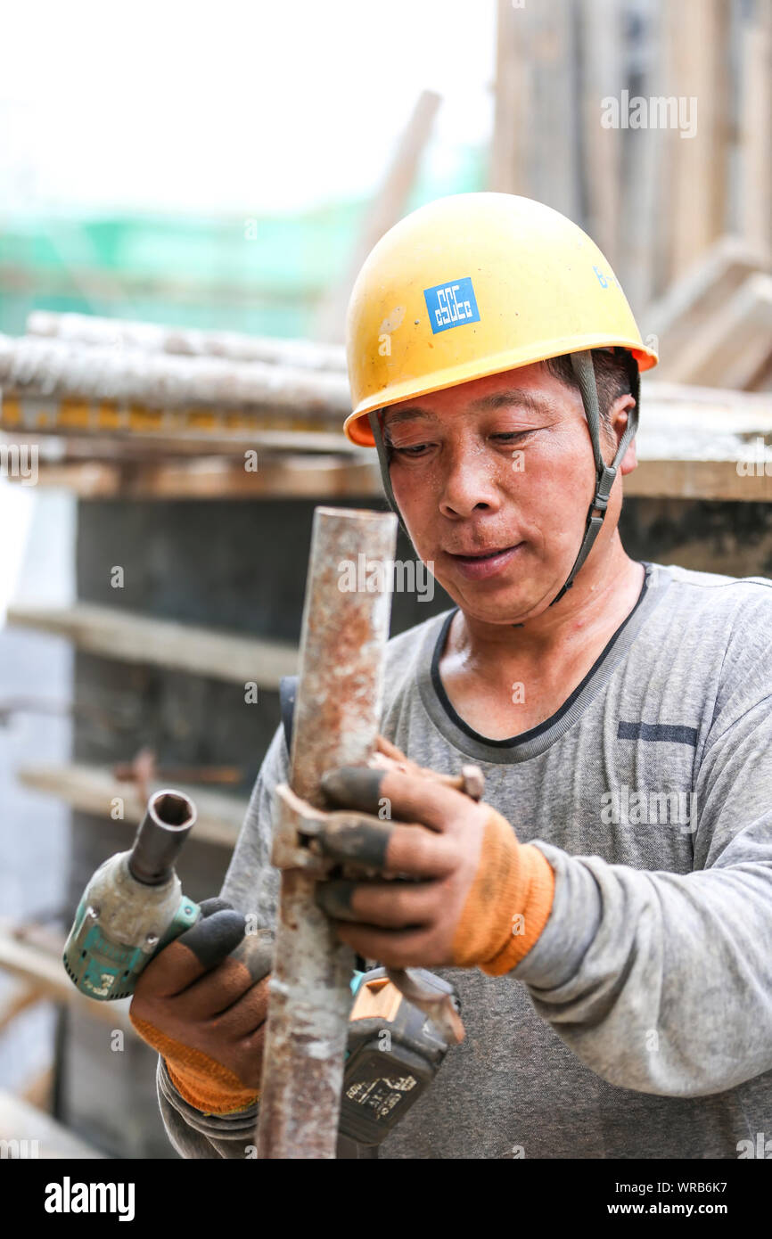 A Chinese migrant worker constructs a high-rise residential apartment ...