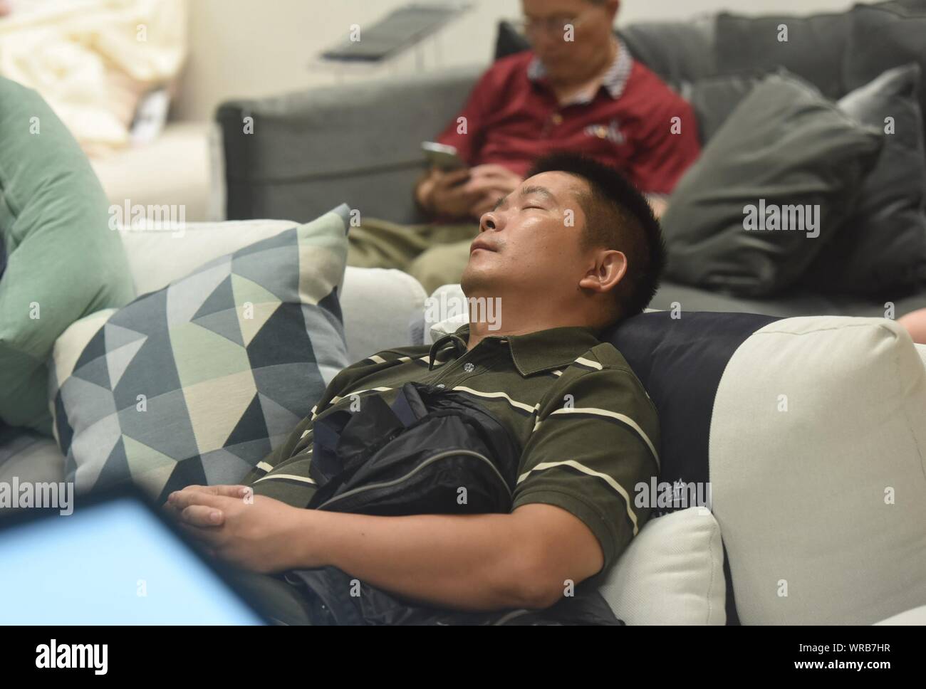 A local Chinese resident naps in the sofa at an air-conditioned IKEA ...