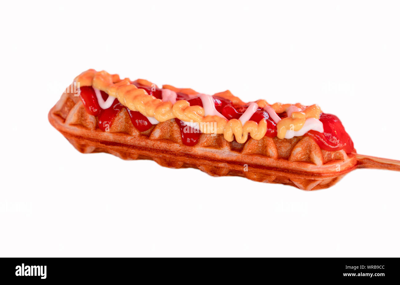 Selective focus of hot dog waffle on a stick in isolated white ...