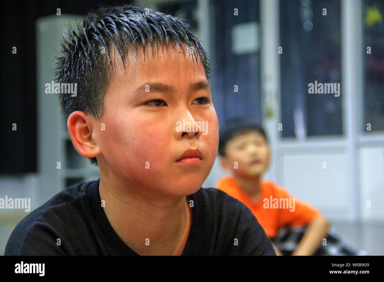 A young Chinese student sweats all over as he and others practise ...