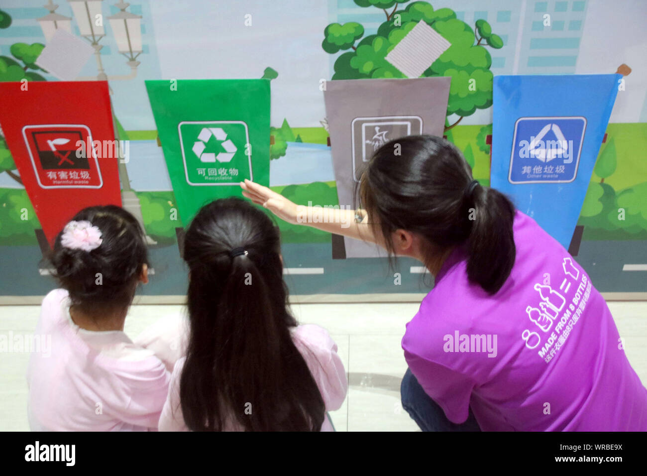 A Chinese sanitation officer teach young kids to sort out garbage ...