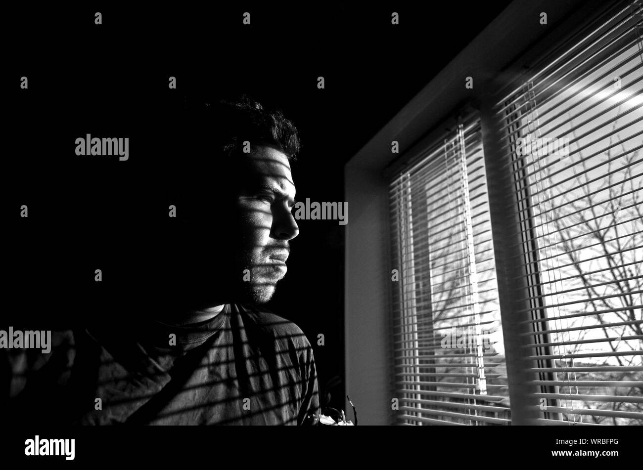 Close up of man looking through window Black and White Stock Photos ...