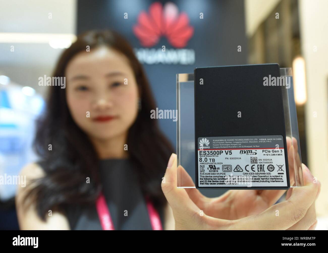 A Chinese hostess shows a 8.0 TB solid state drive (SSD) of Huawei ...