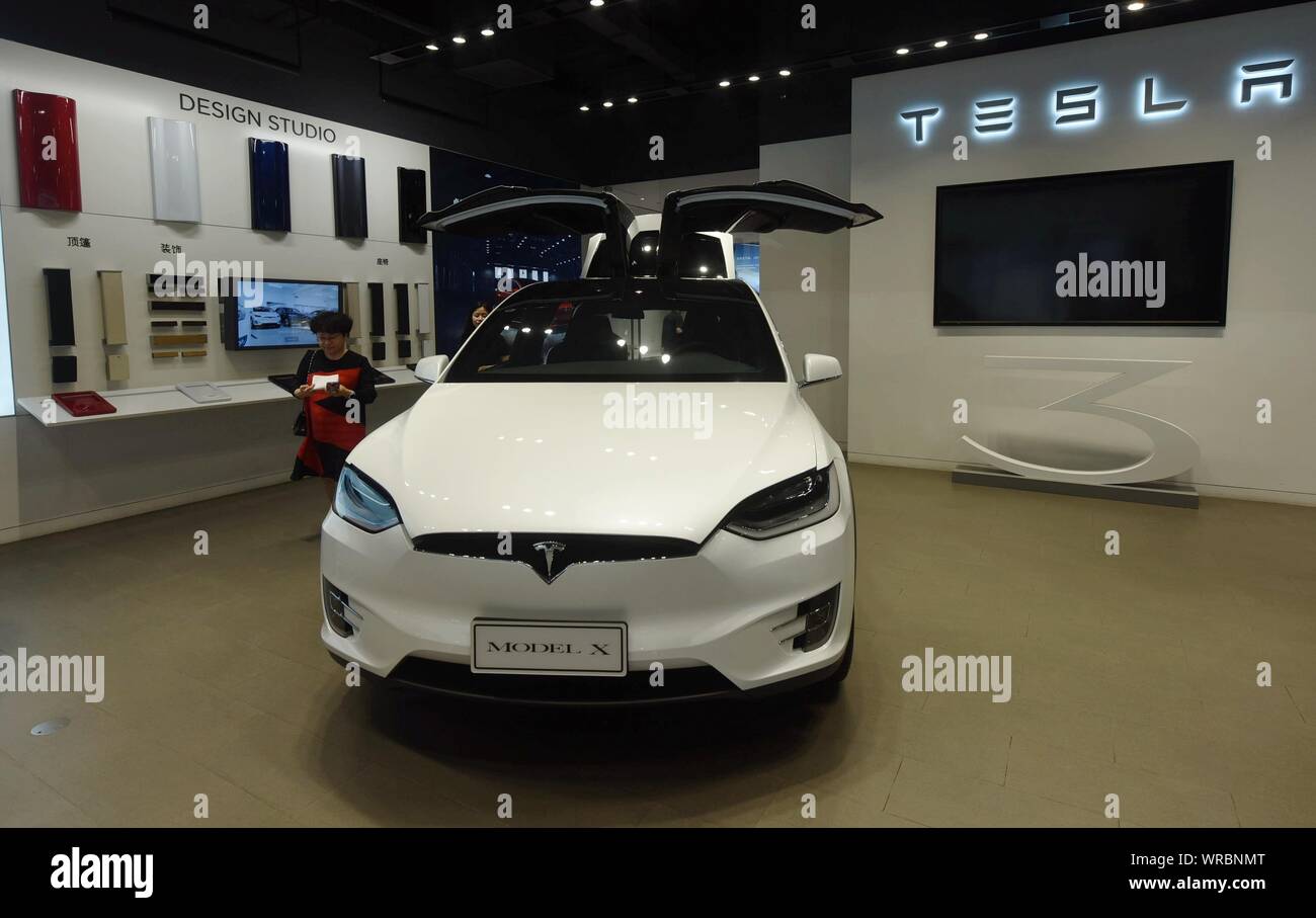 **FILE**Chinese shoppers view a Tesla Model X electric SUV on display ...