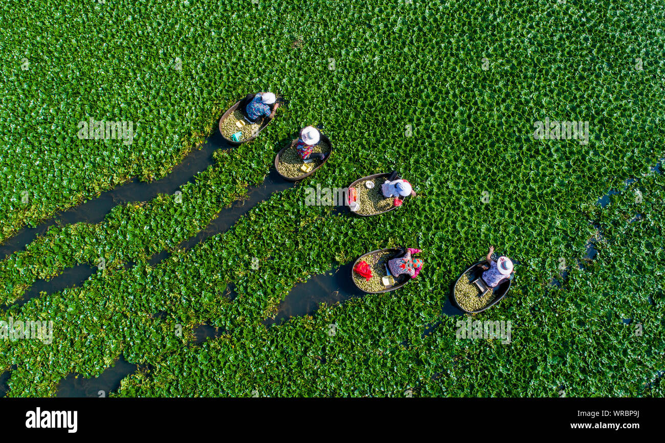 This aerial view shows Chinese villagers sitting in wooden basins ...