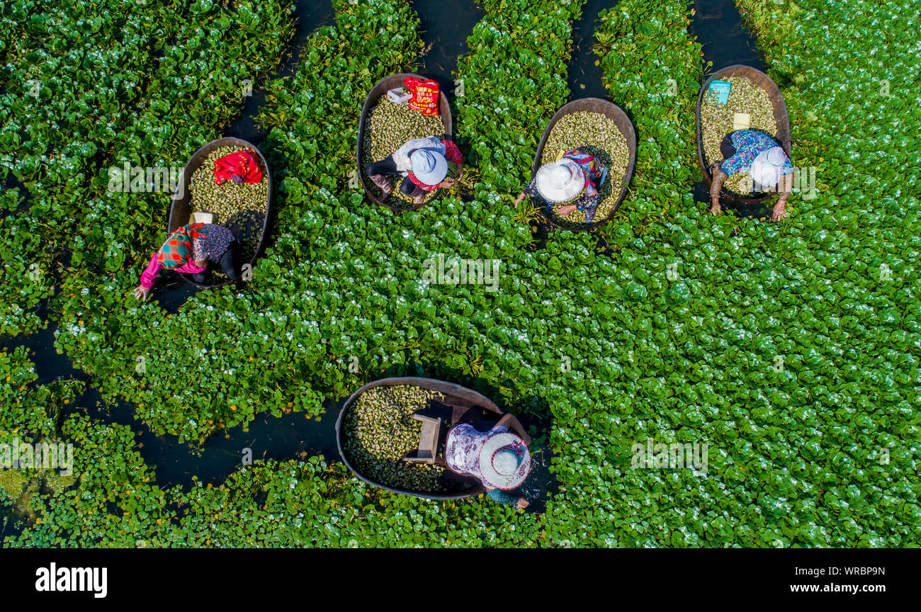 This aerial view shows Chinese villagers sitting in wooden basins ...