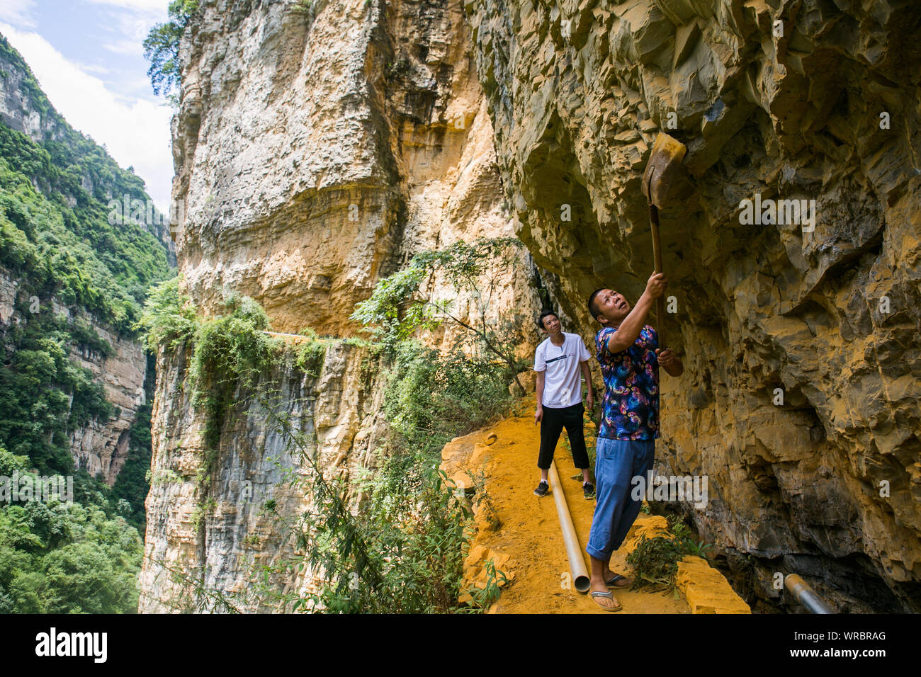 Chinese villagers maintain the Falang Canal built into the cliff in ...
