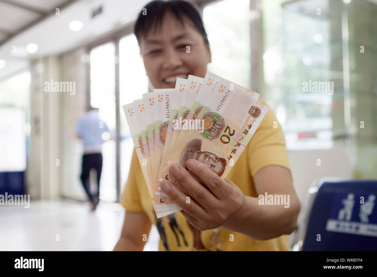 A Chinese resident shows 20-yuan banknotes of the 2019 edition of the ...