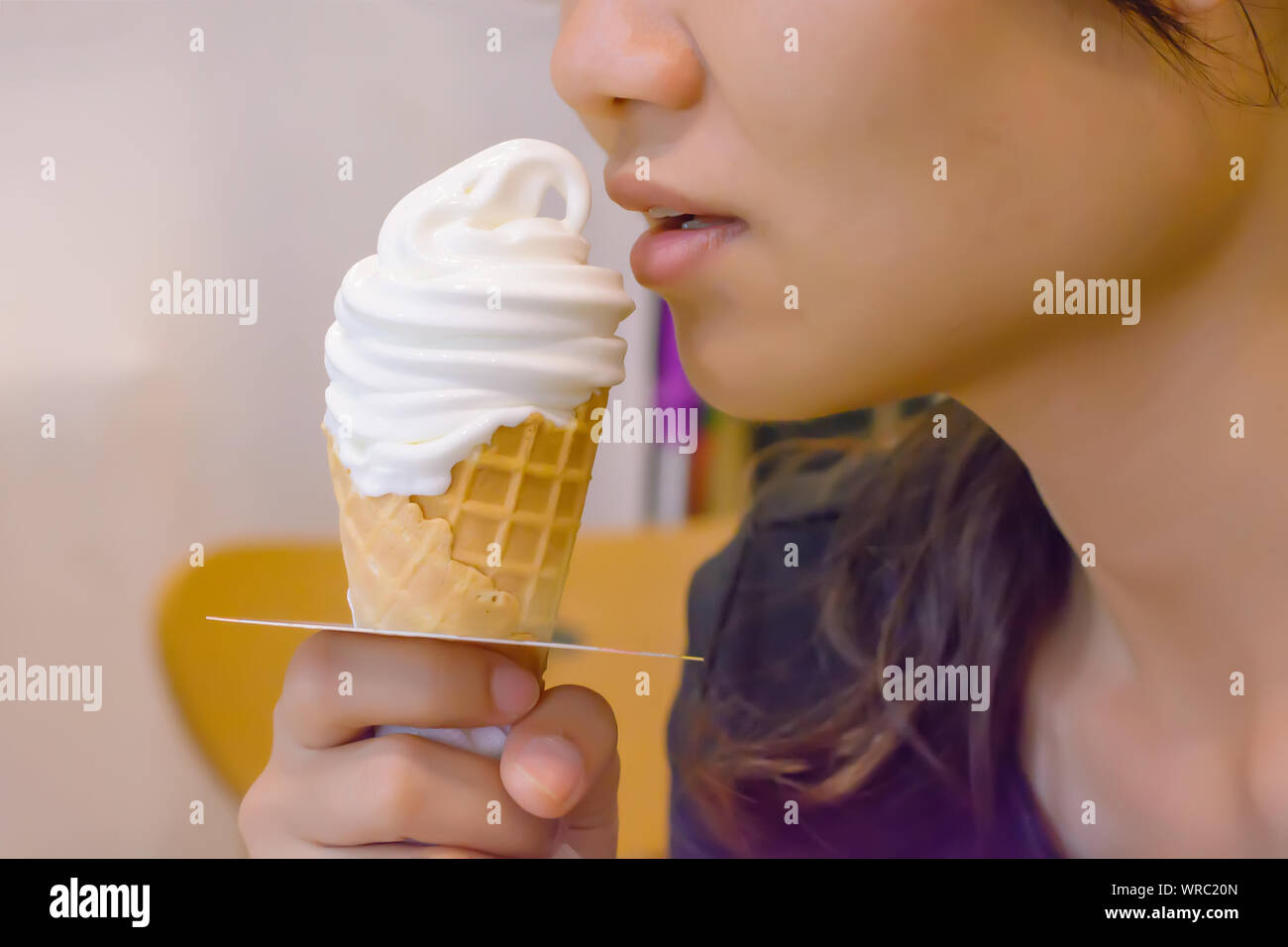 A girl eating ice cream cone white Stock Photo - Alamy