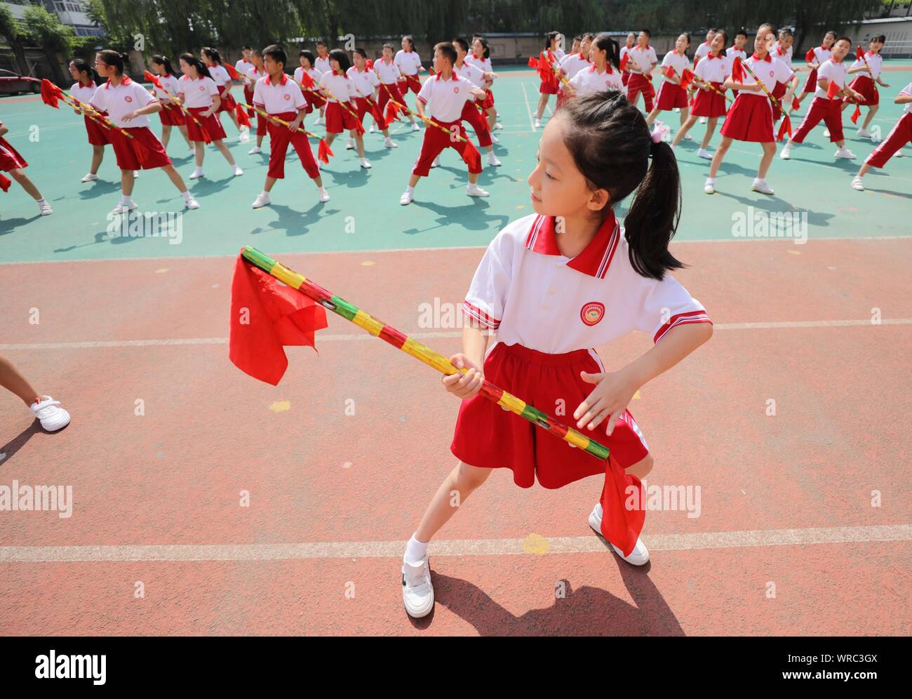 Young Chinese students practice Bawangbian Dance or Rattle Stick Dance ...