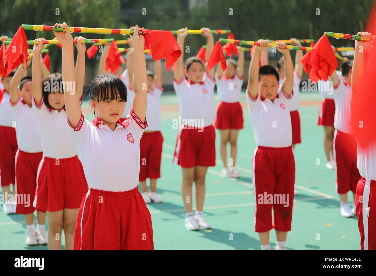 Young Chinese students practice Bawangbian Dance or Rattle Stick Dance ...