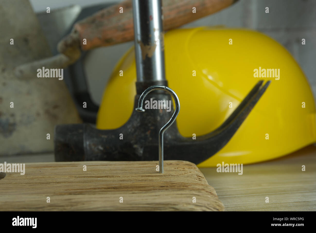 Construction nail shaped as question mark with blurred background of ...