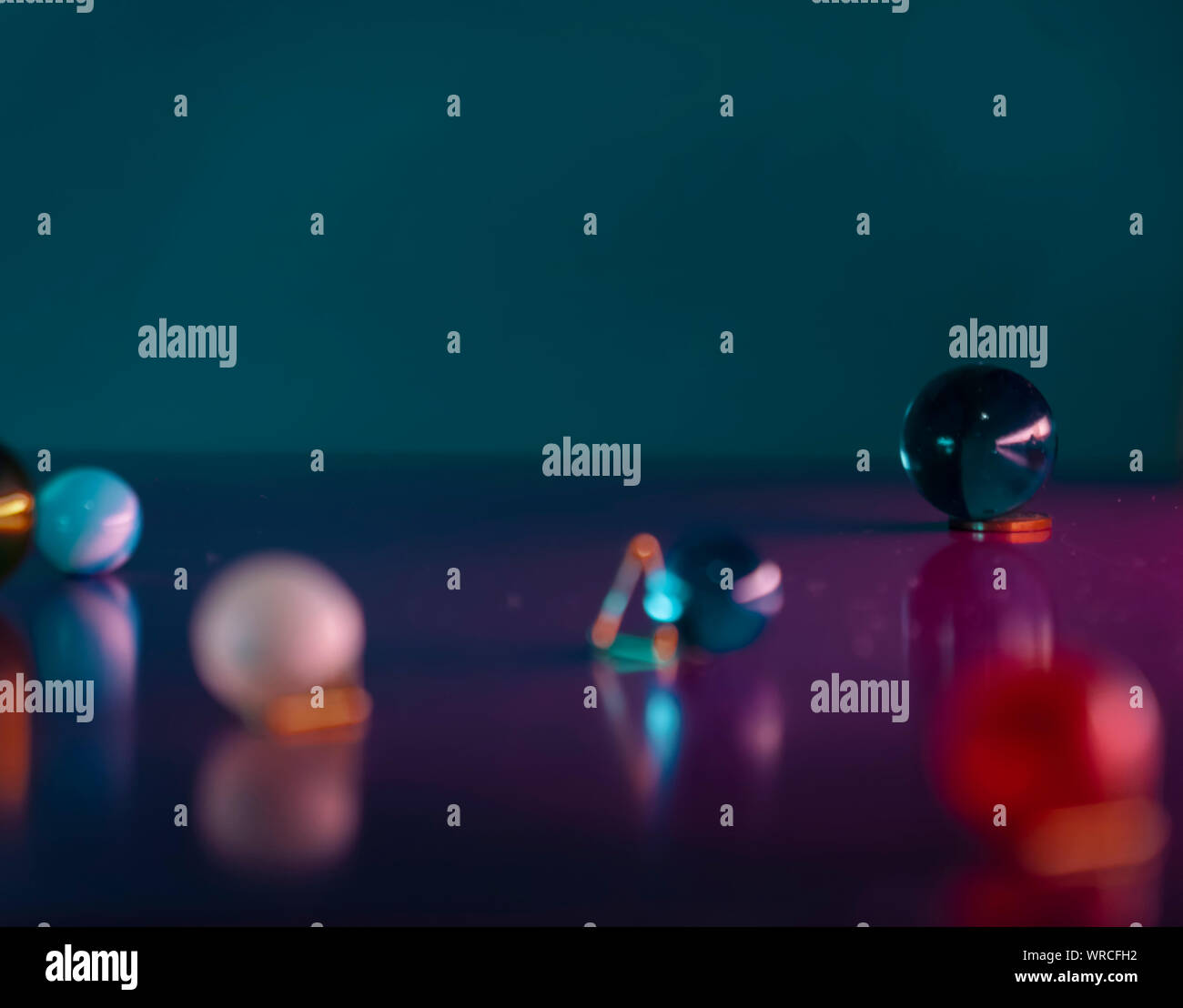 Glass marble balls on purple table Stock Photo - Alamy
