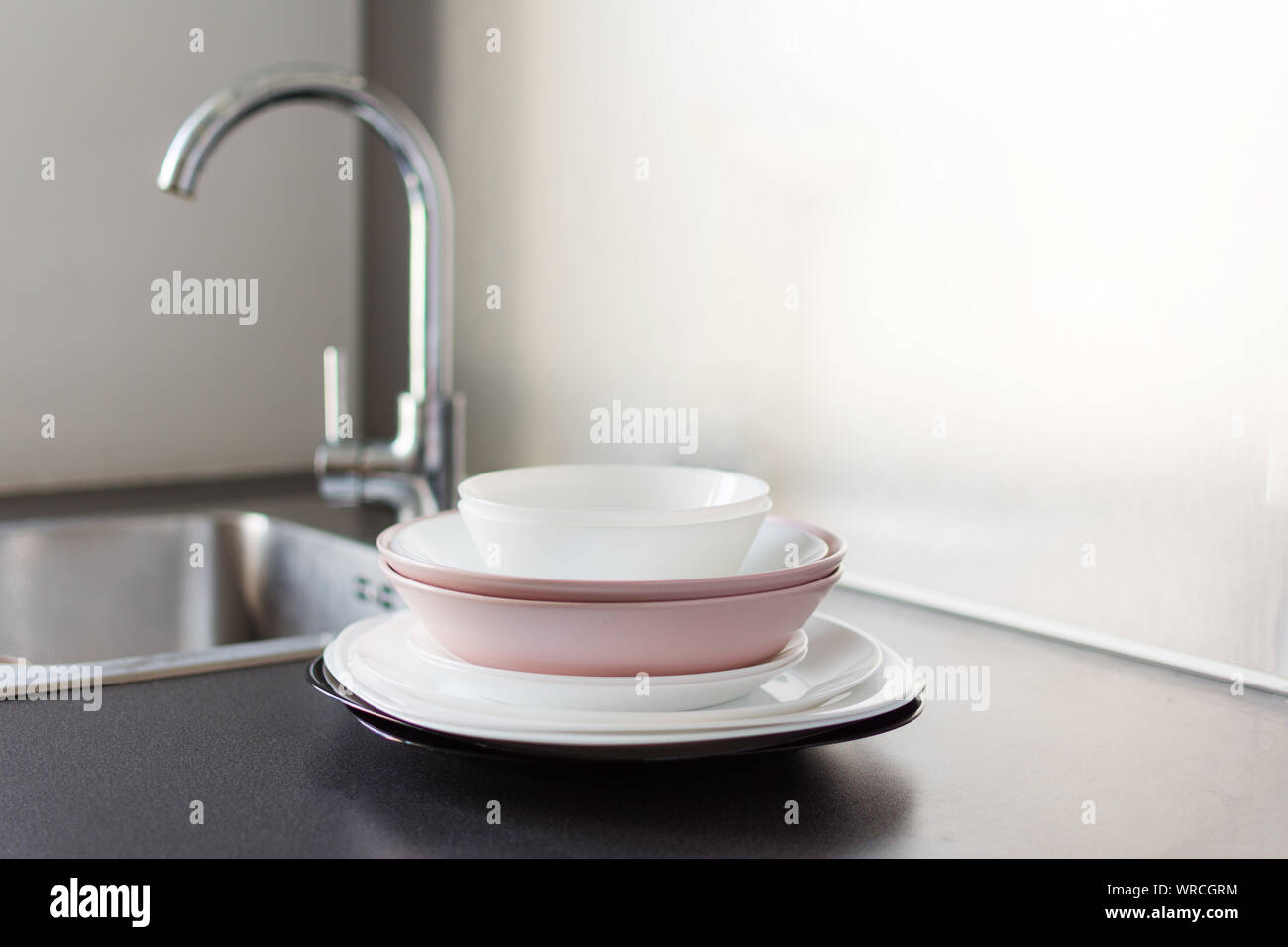 Set of fresh washed plates and cutlery on the kitchen gray table Stock ...