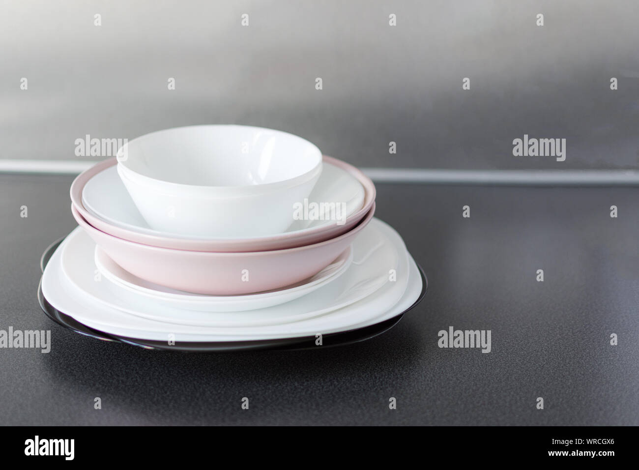 Set of fresh washed plates and cutlery on the kitchen gray table Stock ...