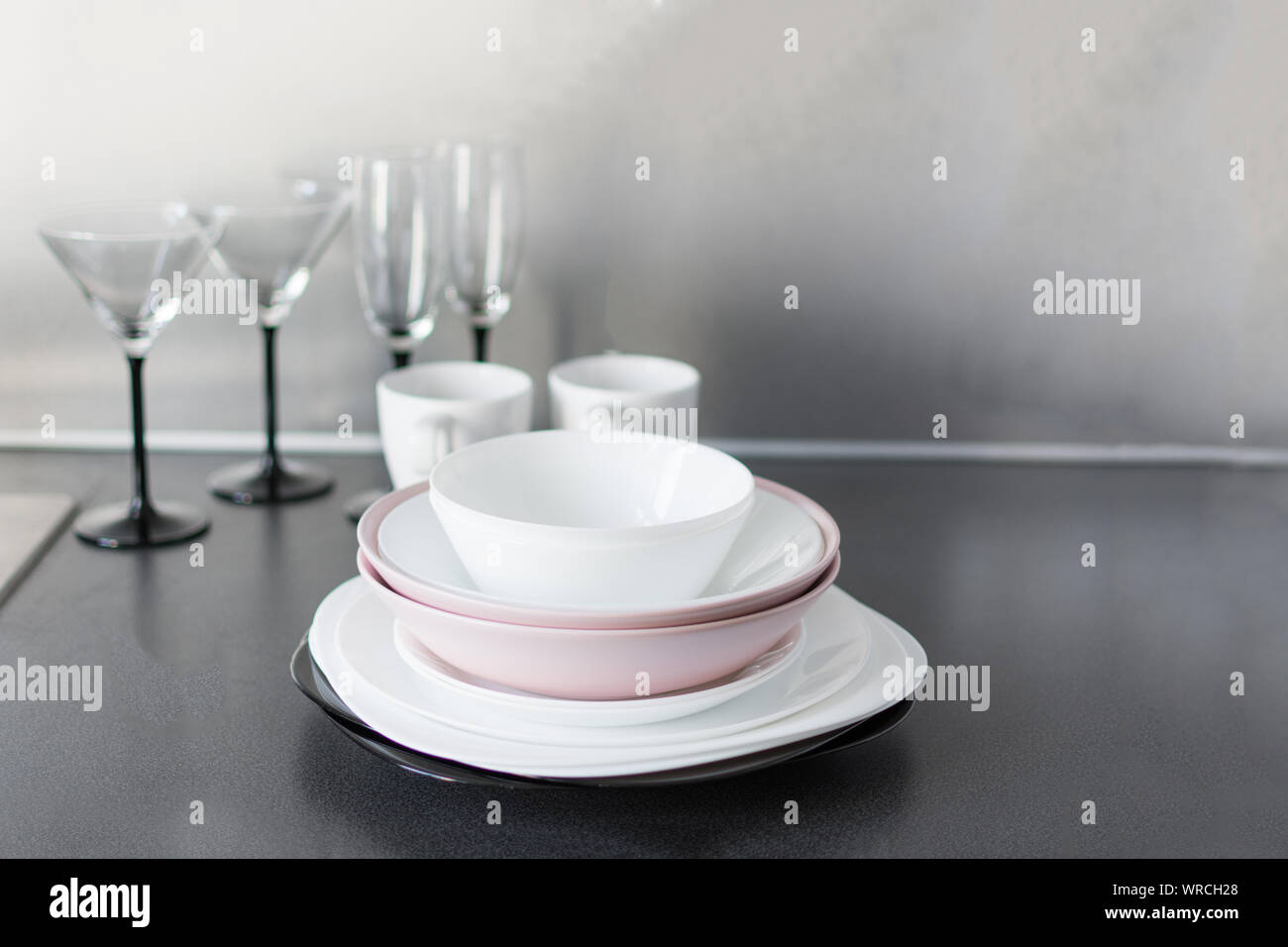 Set of fresh washed plates and cutlery on the kitchen gray table Stock ...