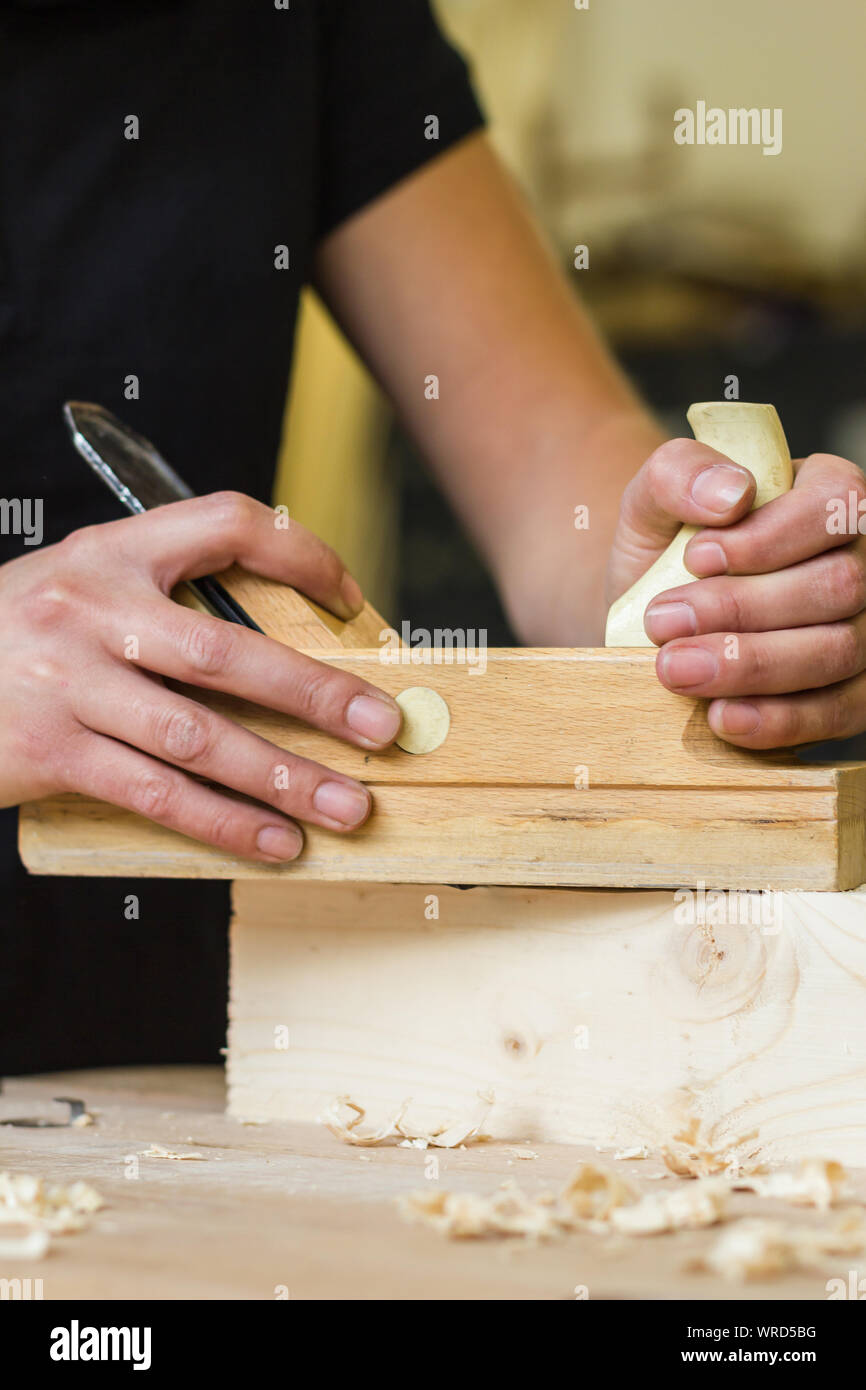 female carpenter carpenter with planer hand planer and wood in workshop ...