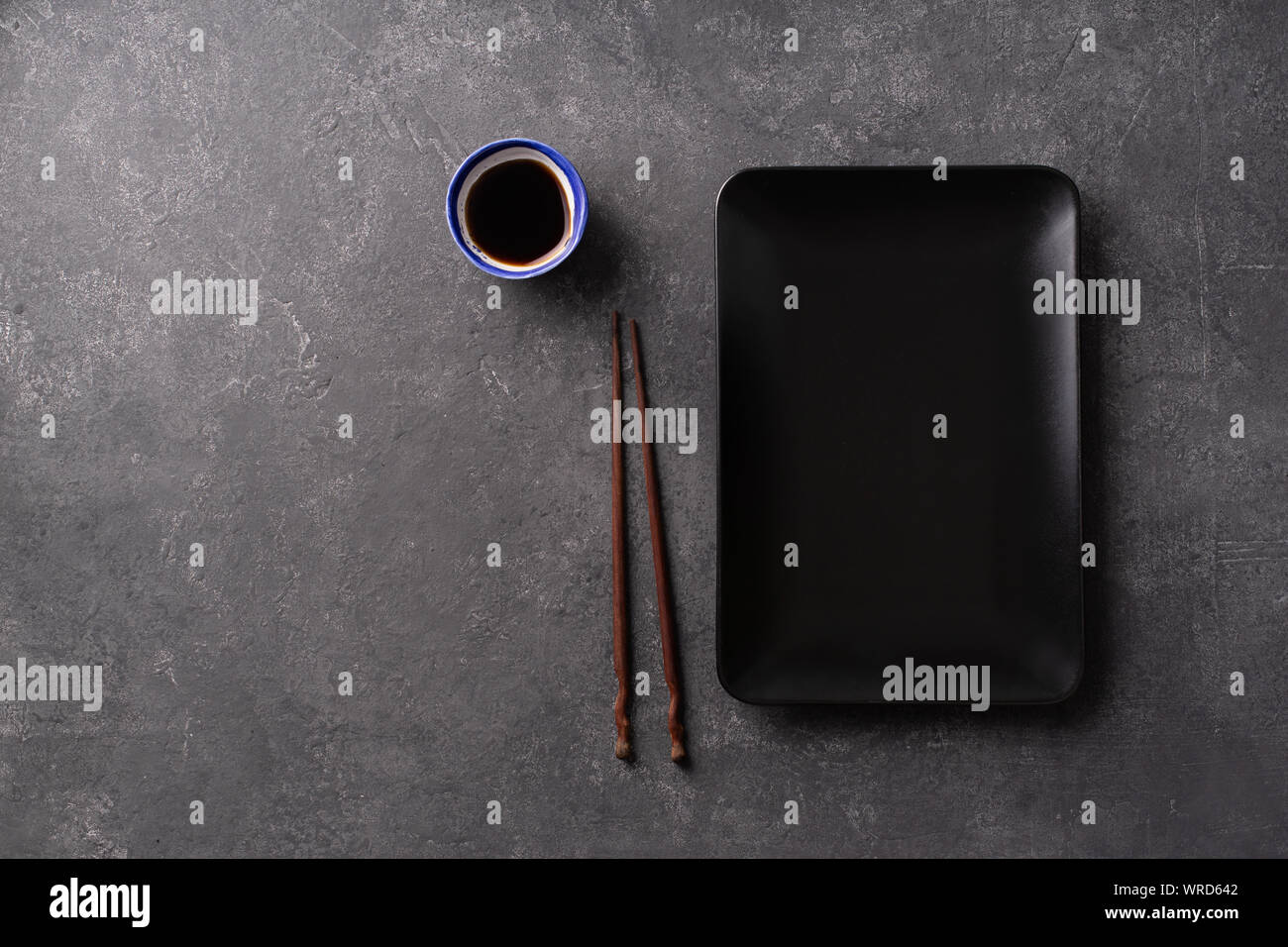 Empty black plate for sushi with wooden chopsticks and soy sauce Stock ...