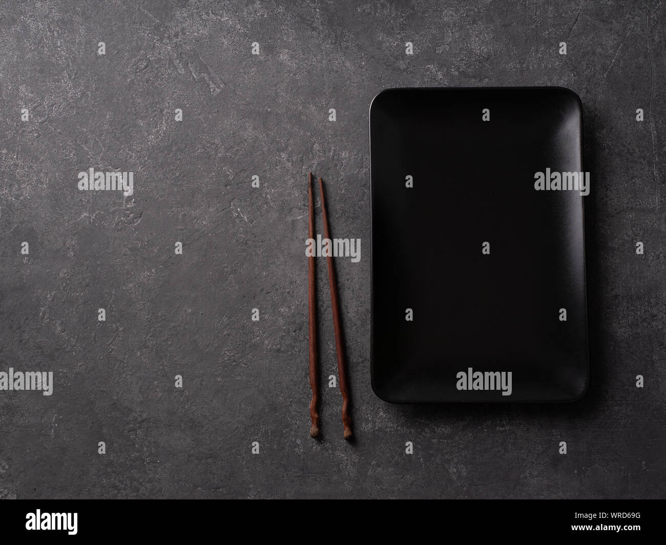 Empty black plate for sushi with wooden chopsticks Stock Photo - Alamy