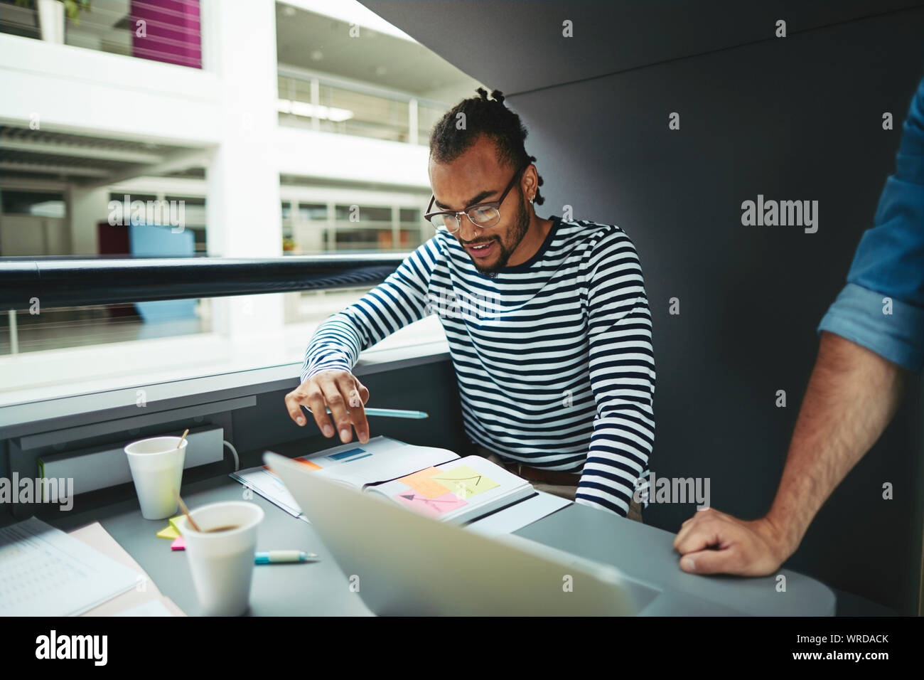 Focused young African American businessman going over notes while ...