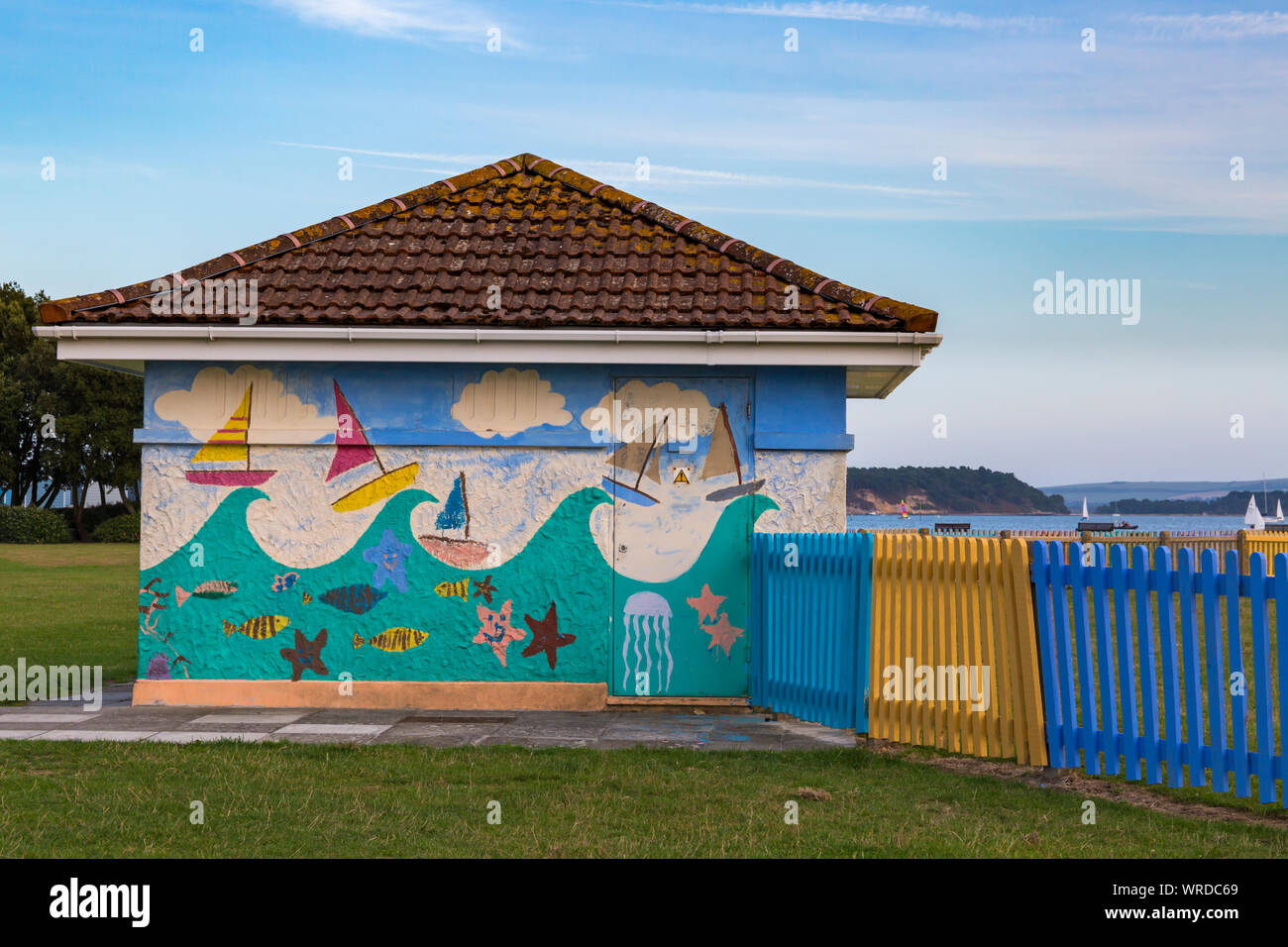 Colourful hut with painted artwork on side and painted fences at ...
