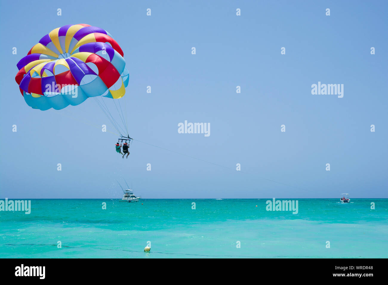 Colorful parasail wing flying over turquoise water of Sargasso Sea ...