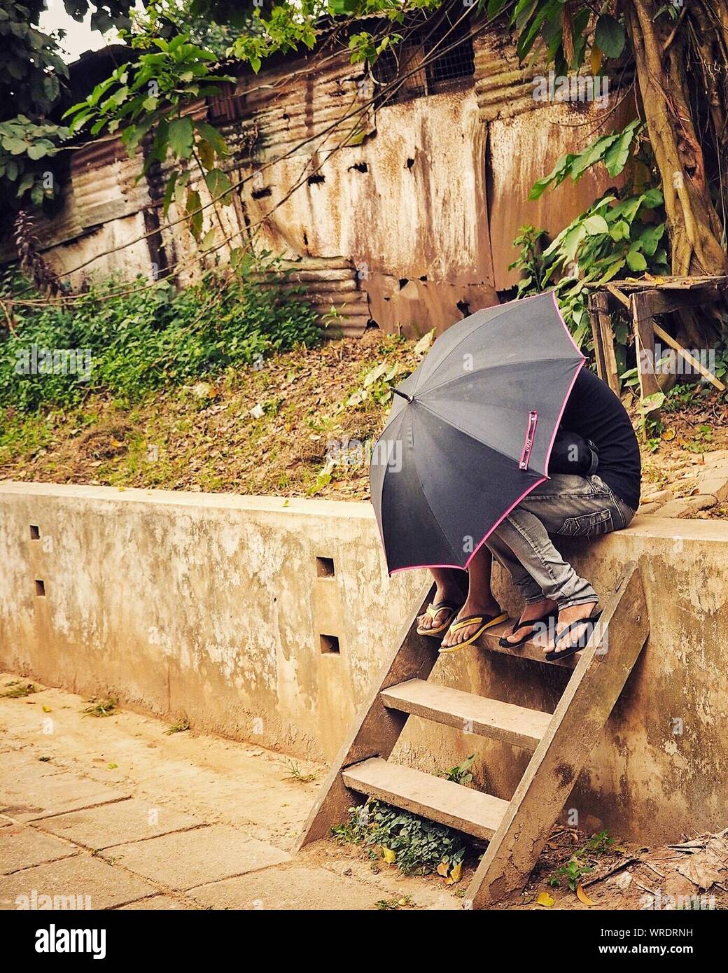 Hiding under an umbrella hi-res stock photography and images - Alamy