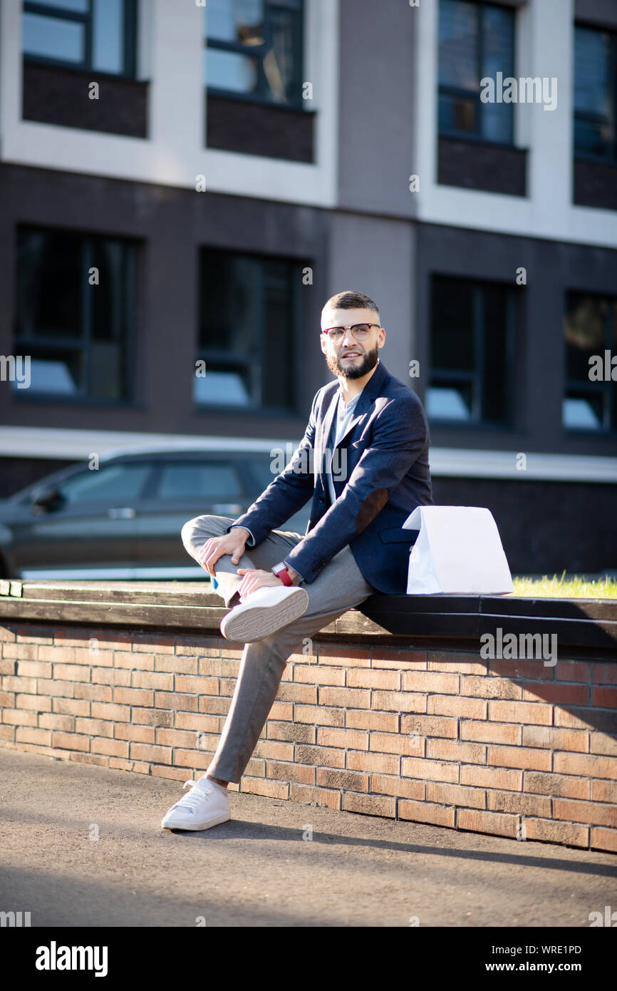 Handsome stylish man sitting outside near the office building Stock ...