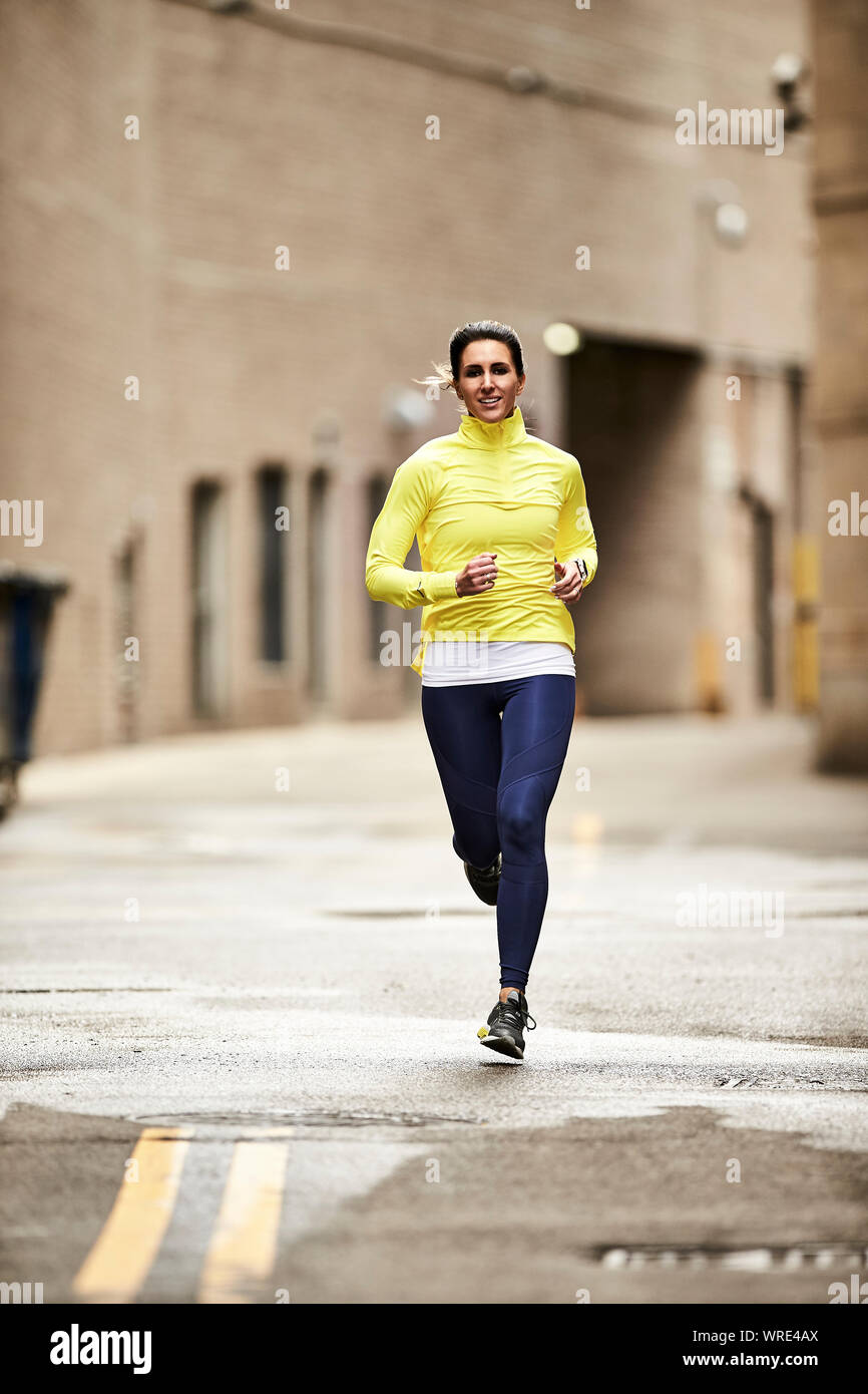 A close up of a woman running down a gritty city street in Boston Stock ...