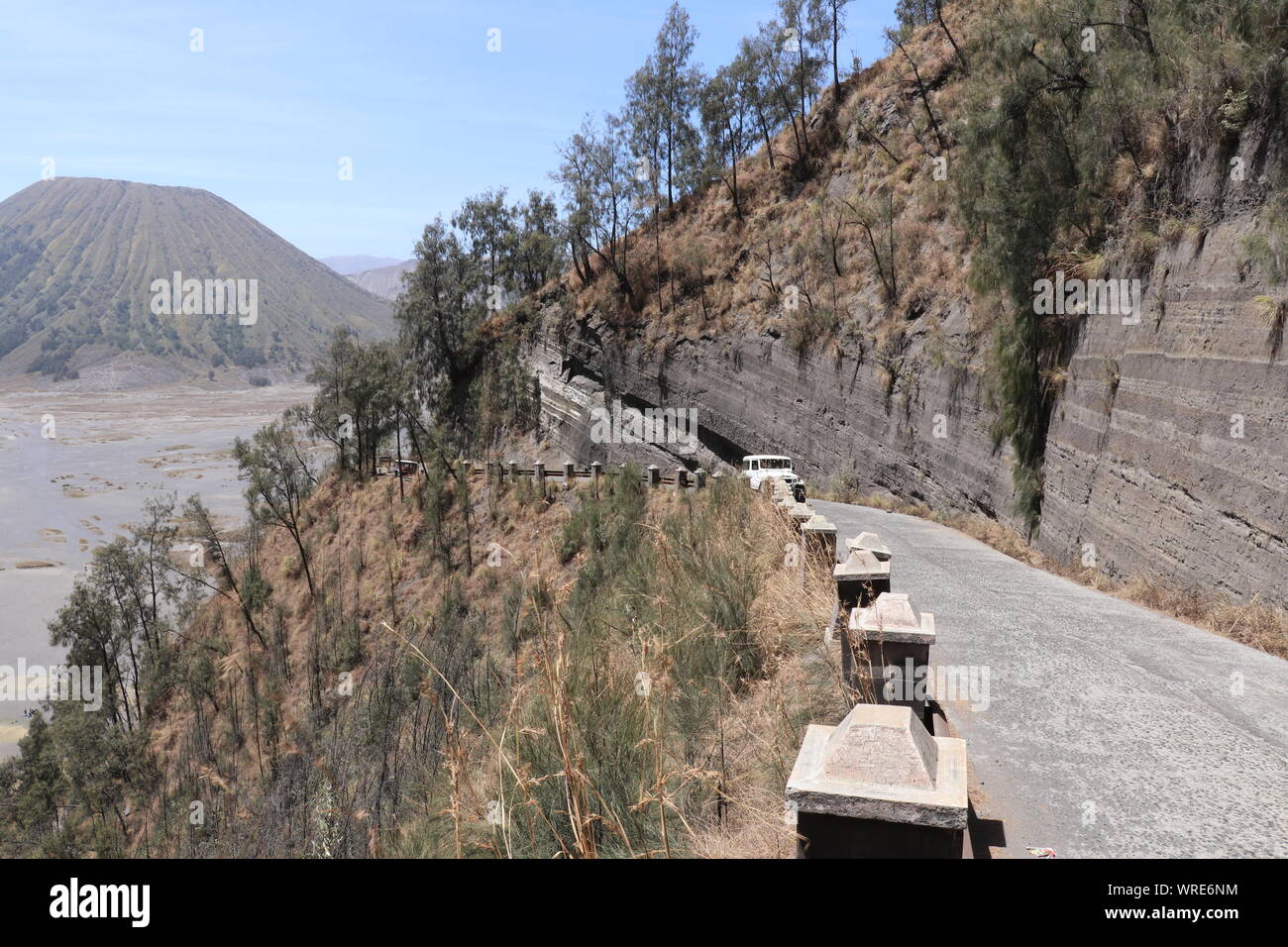 Off-road jeeps go up a steep hill on the slope of Bromo caldera to the ...