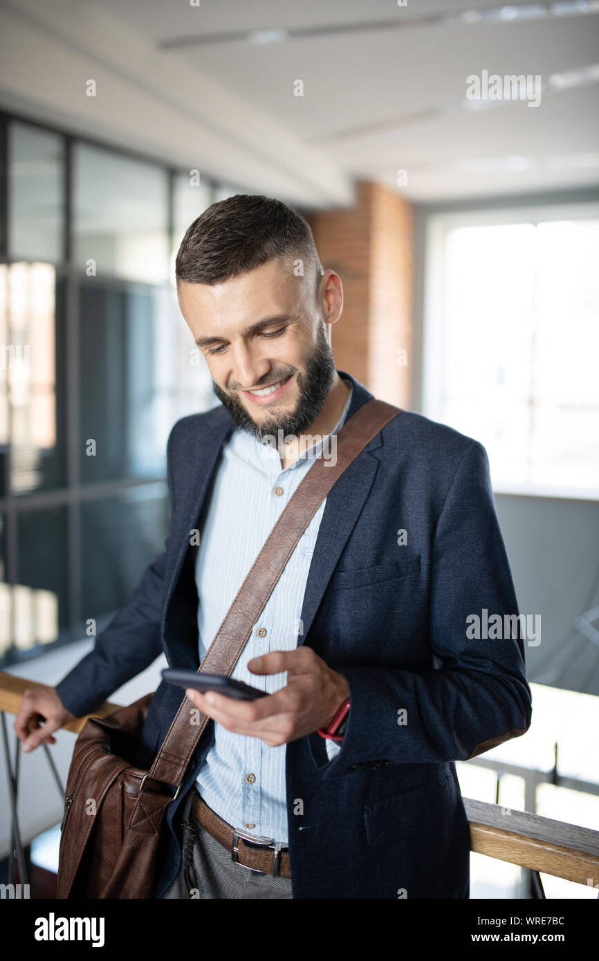 Man reading message on phone while having little break Stock Photo - Alamy