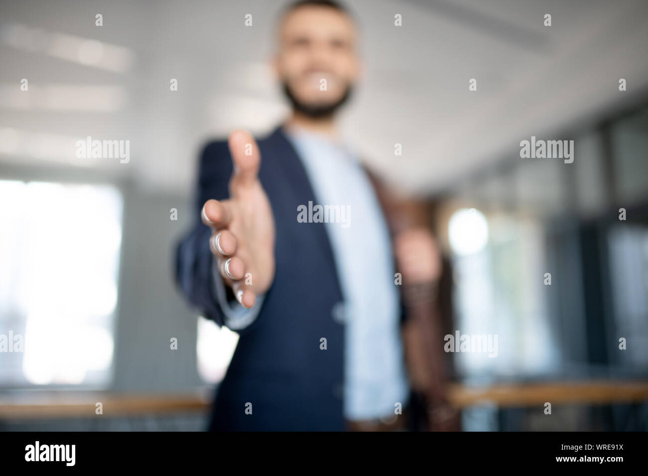Businessman reaching his hand out while meeting partner Stock Photo - Alamy