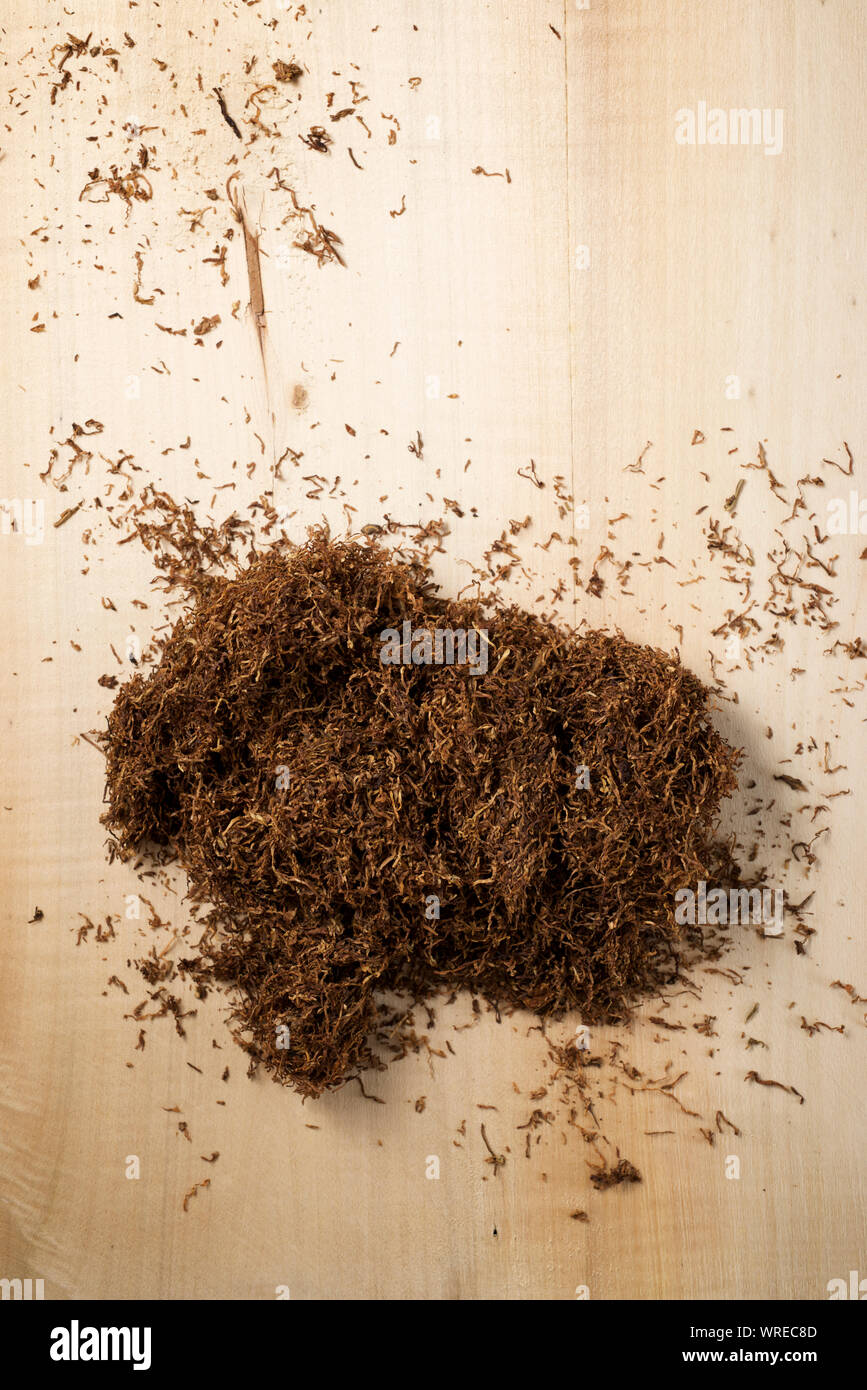 Hand rolling tobacco on a wood table Stock Photo - Alamy