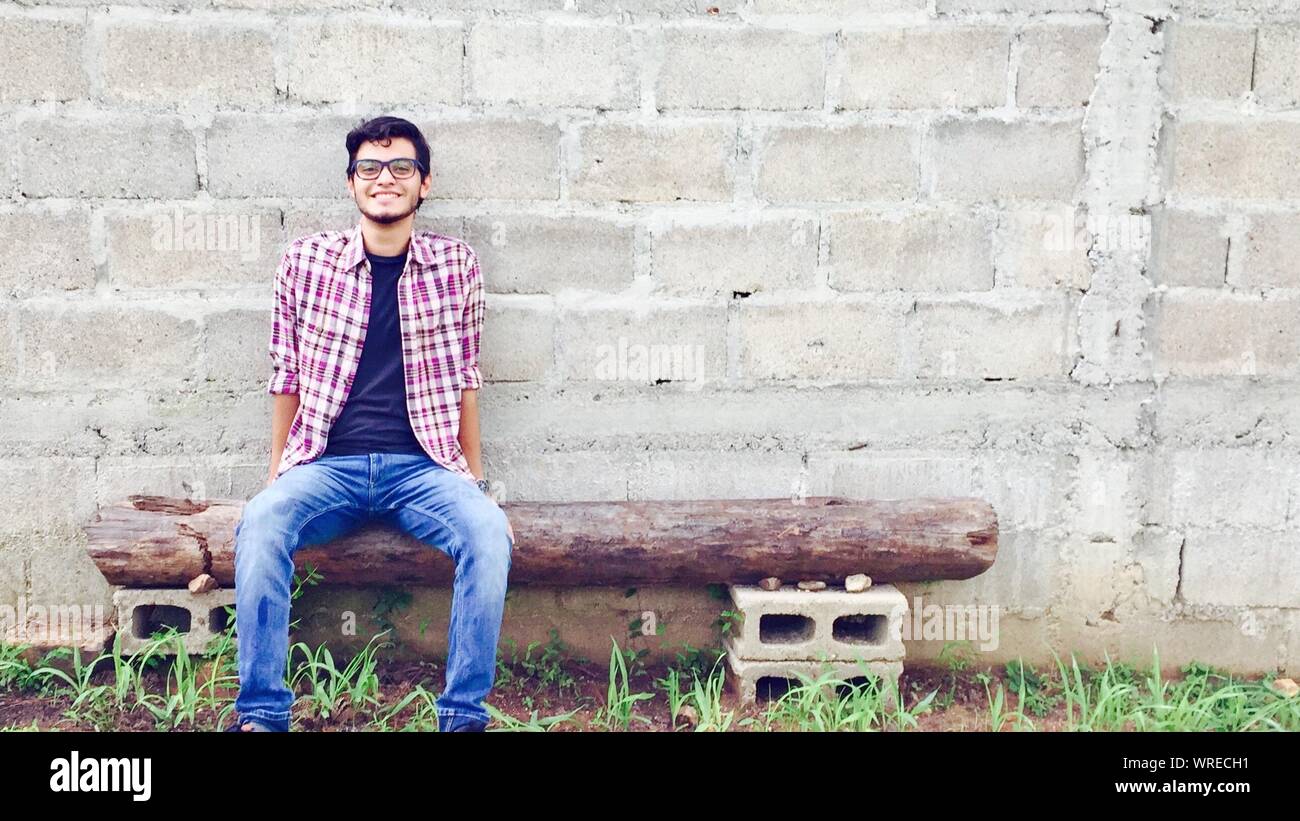 Man sitting on brick wall hi-res stock photography and images - Alamy