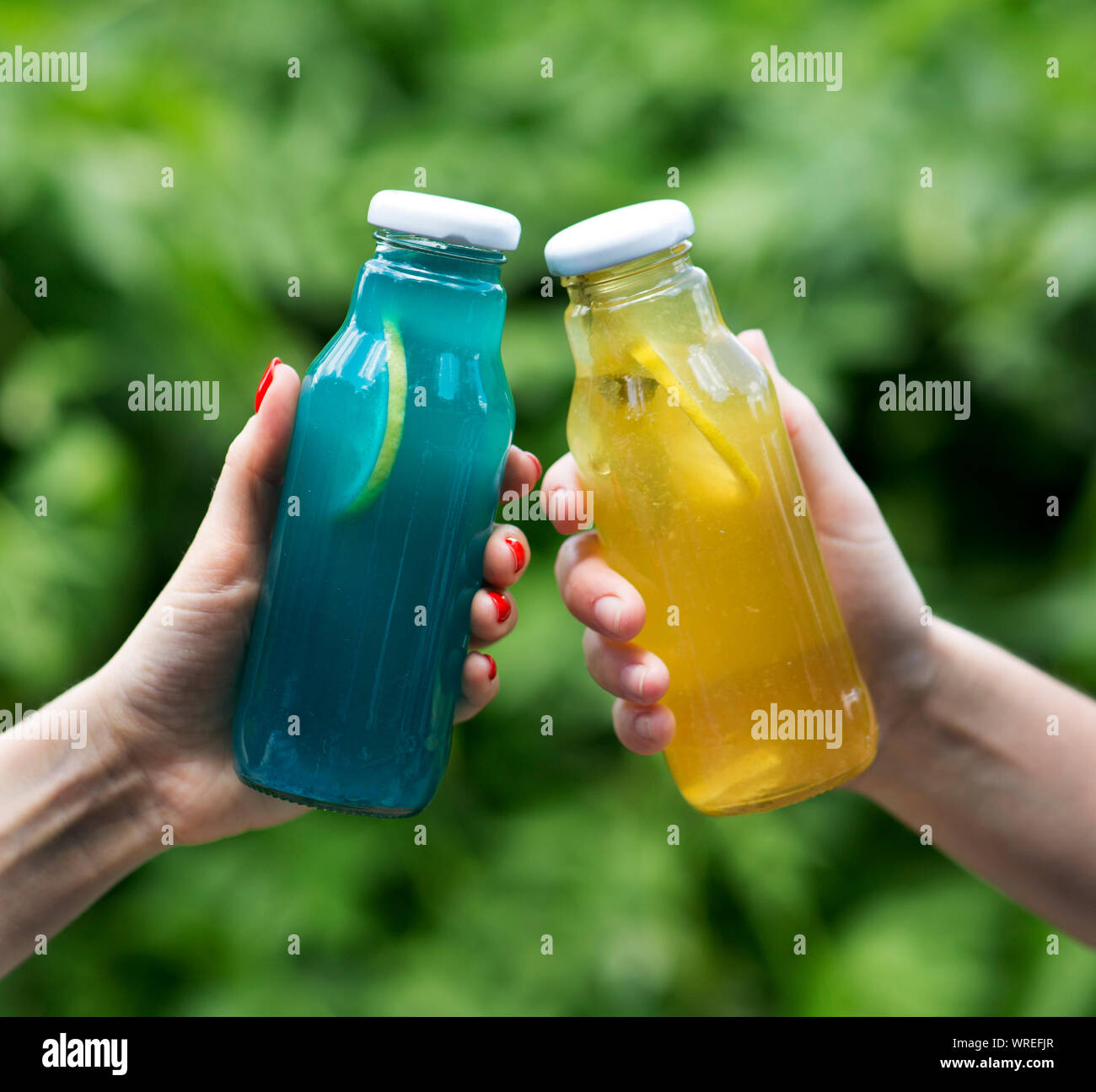 Blue Isotonik and detox lemonade in woman hands outdoor Stock Photo - Alamy