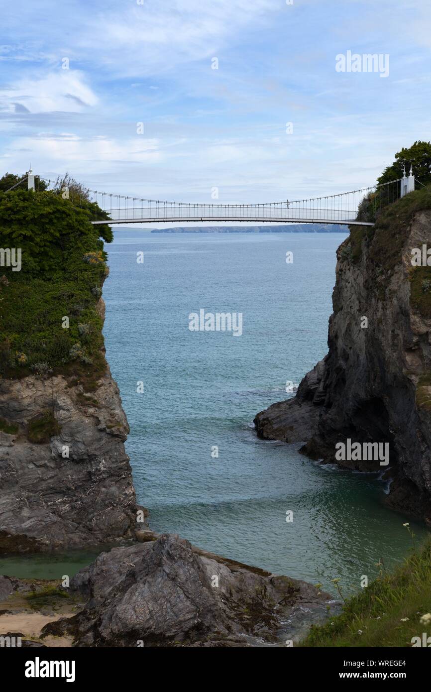 Towan Beach in Newquay, Cornwall. A suspended footbridge between two ...