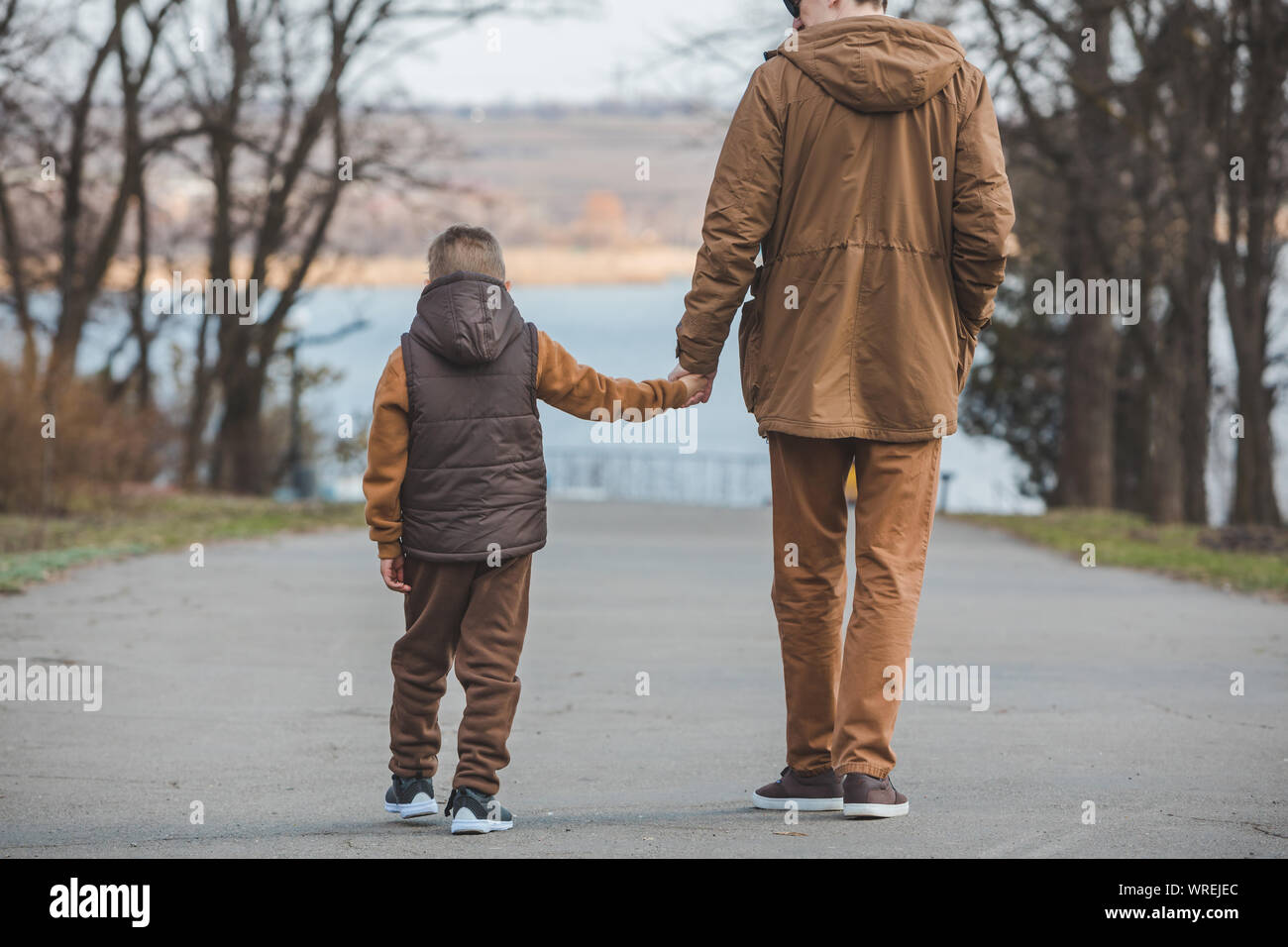 father with son walking by park holding hands Stock Photo - Alamy