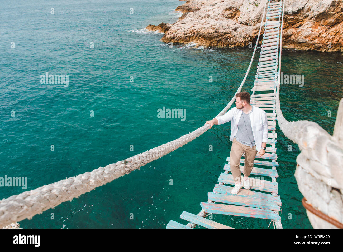 man walking by suspension bridge Stock Photo - Alamy
