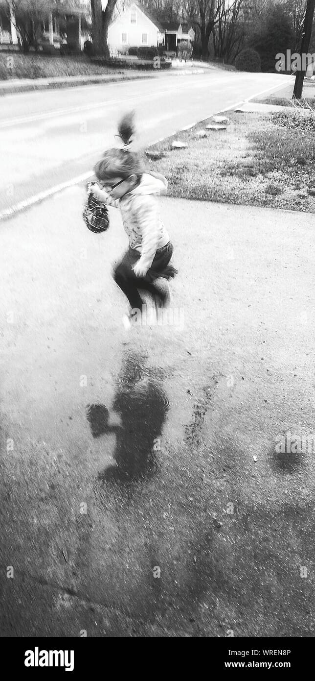 Girl jumping into puddle hi-res stock photography and images - Alamy