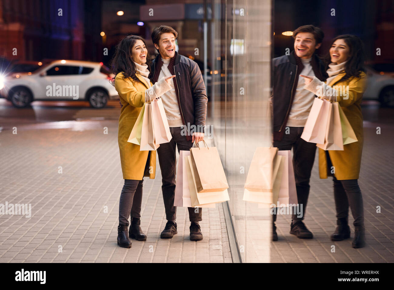Weekend shopping. Couple looking into shop window Stock Photo - Alamy