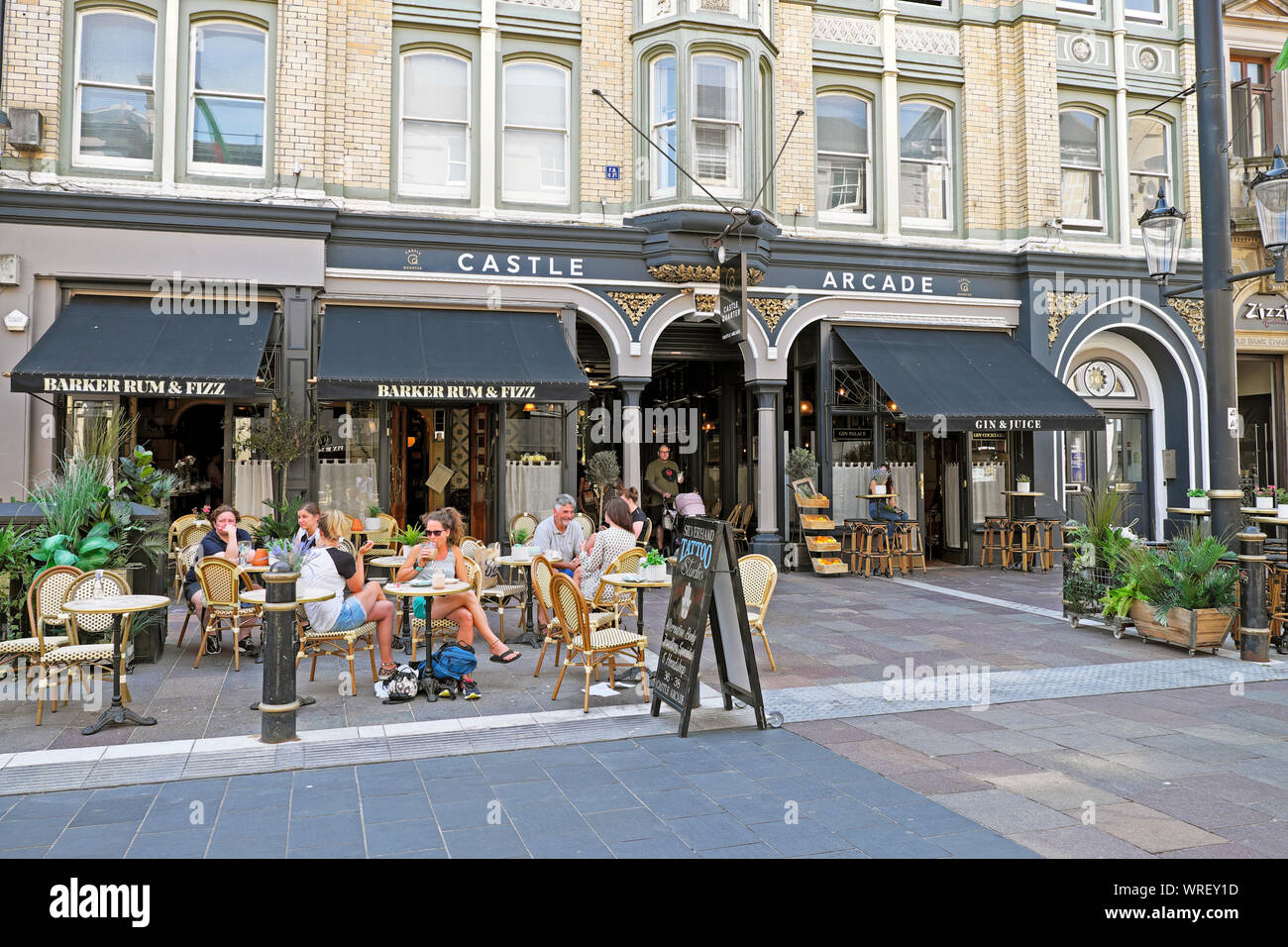 People sitting at tables outside Barker Rum & Fizz bar restaurant ...