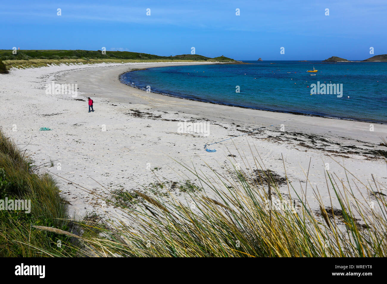 A solitary person walking on Higher Town Bay, St. Martin’s Island ...